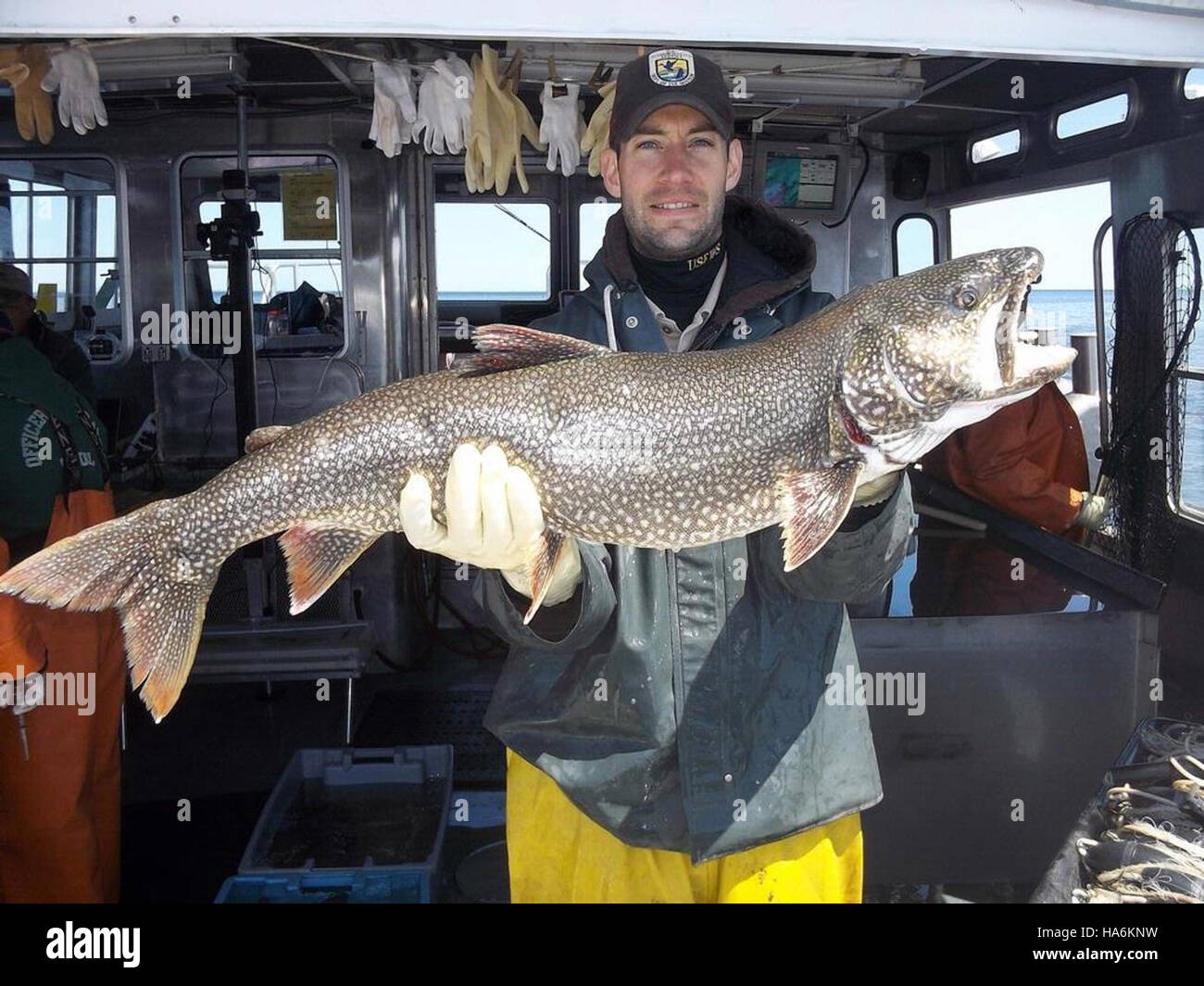Fish biologist Kevin Pankow presents a lake trout captured in a gill ...