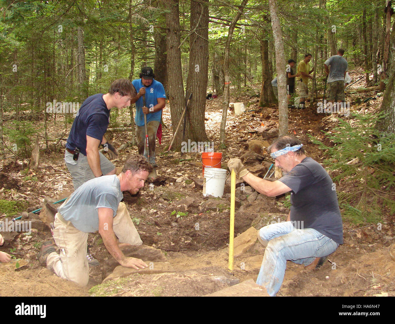 Volunteers work on trail maintenance by constructing drainage systems ...