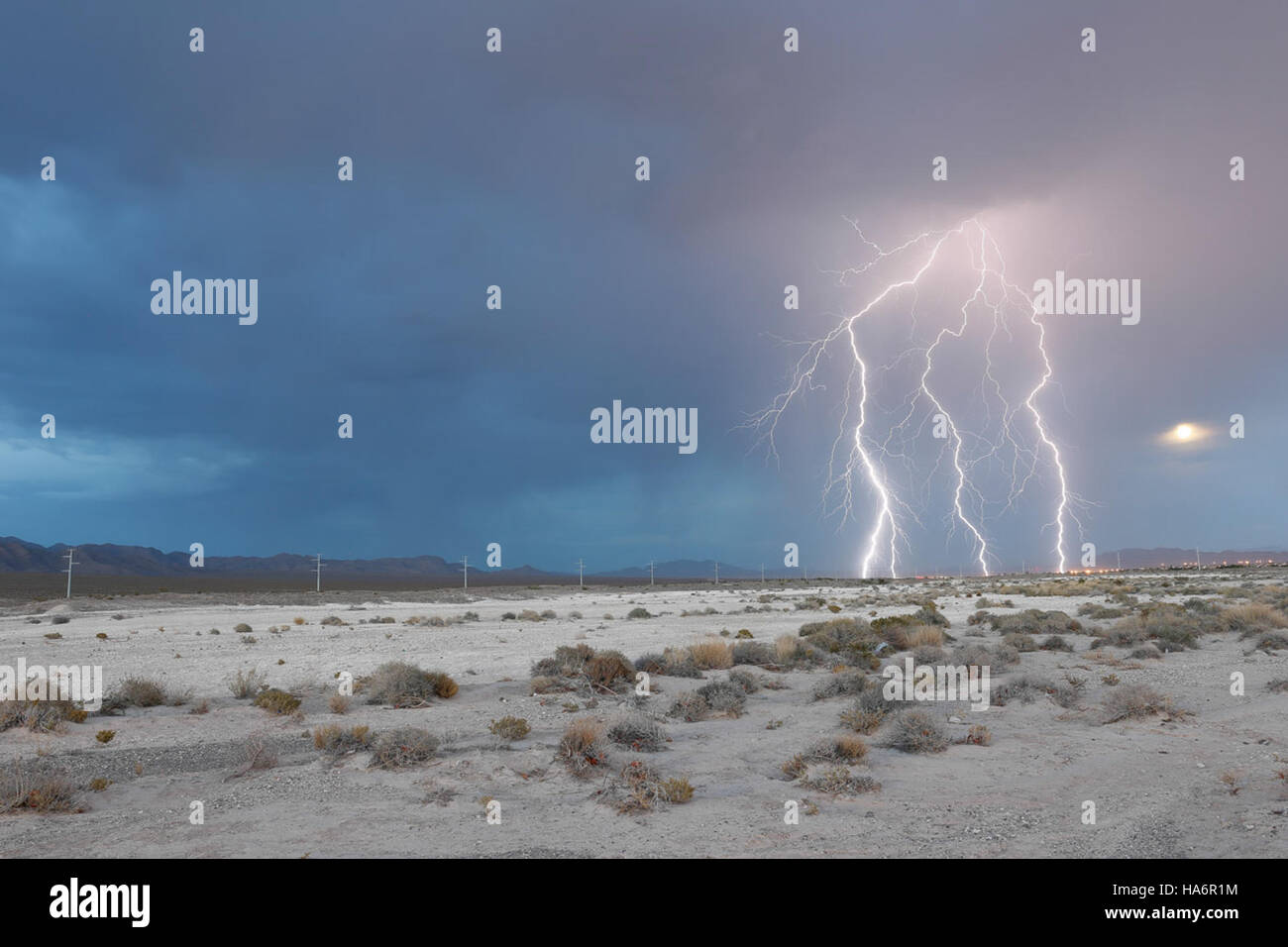 A powerful lightning strike illuminates the desert landscape, a natural ...