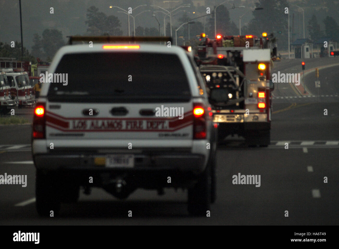This photograph shows emergency vehicles responding to a wildfire along ...
