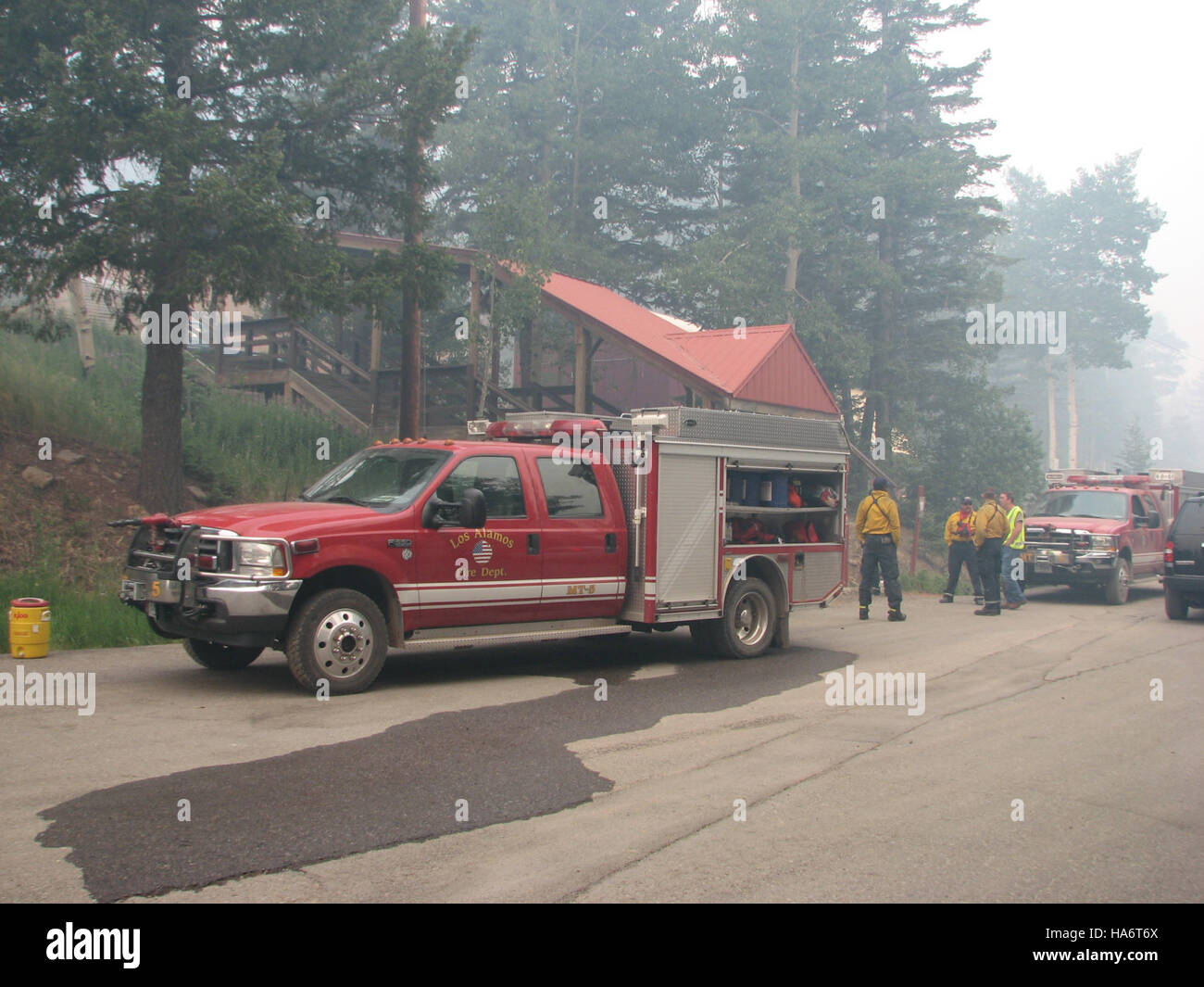 A photograph of Los Alamos National Laboratory firefighters assessing a ...