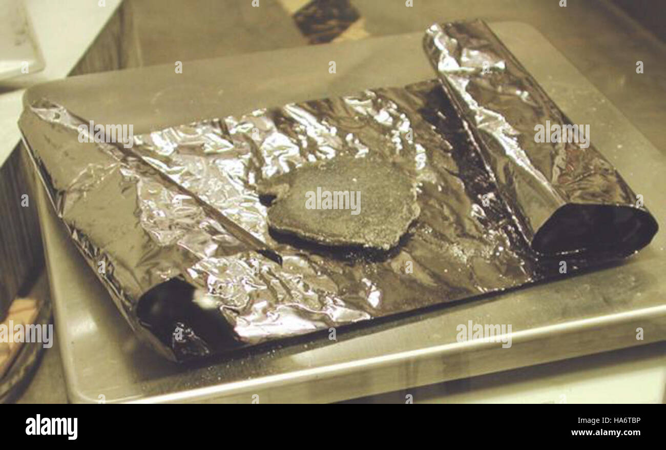 This image features a plutonium-238 metal button from Los Alamos ...