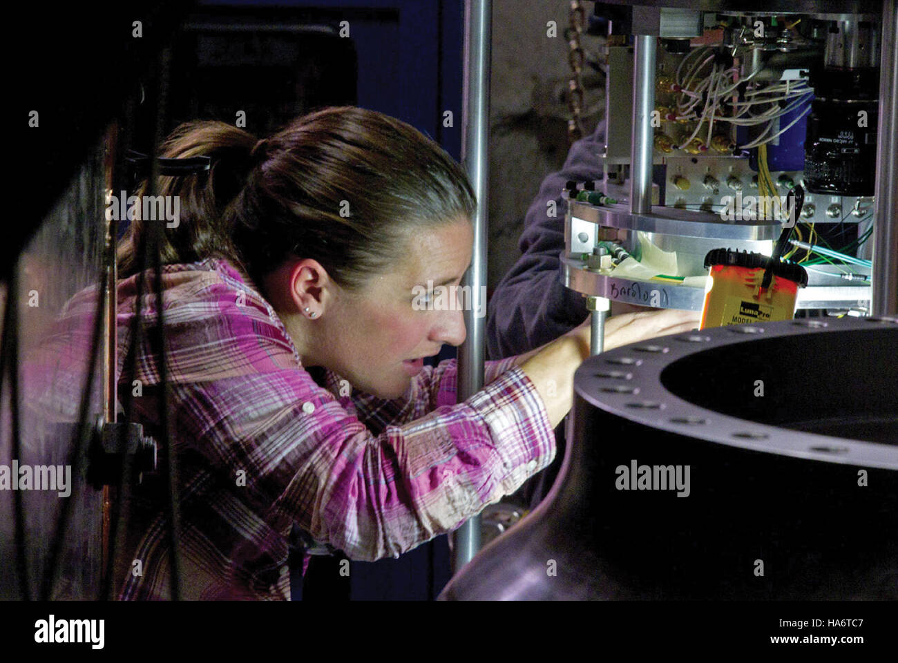 This image shows a worker checking a laser diagnostic tool used in the ...