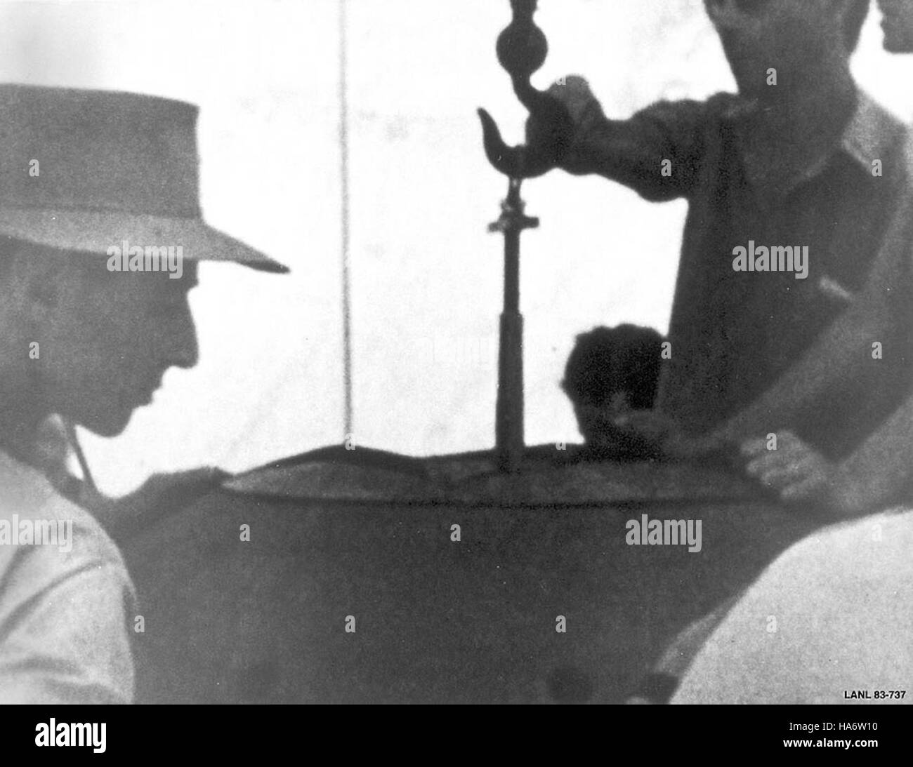 This image depicts J. Robert Oppenheimer overseeing the final assembly ...