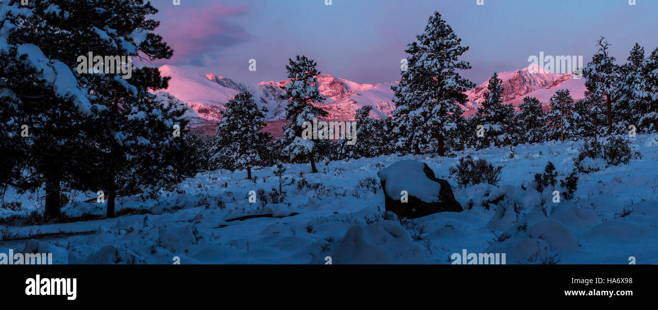 Alpenglow is visible over Rocky Mountain National Park, casting a ...