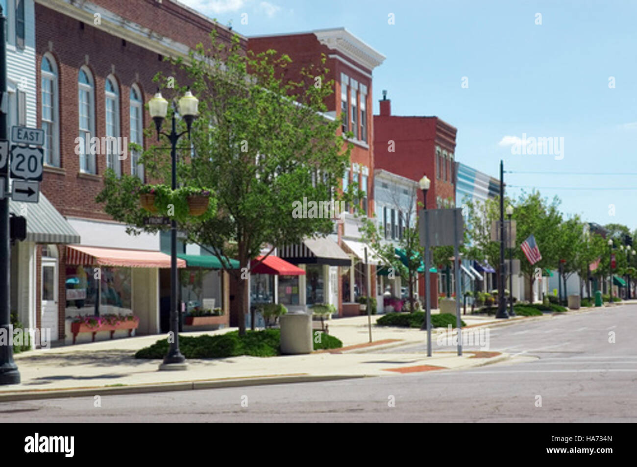 This image portrays a rural road scene in America, with open fields and ...