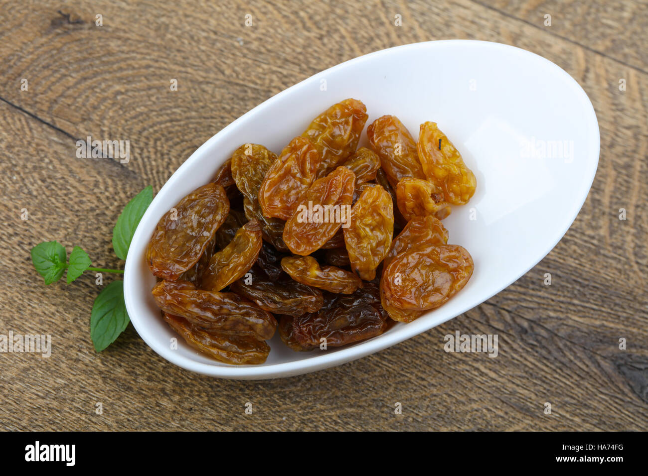 Sweet raisins in the bowl with mint leaves Stock Photo - Alamy