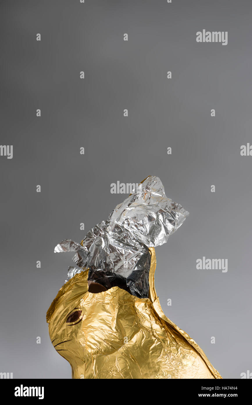 Chocolate Easter bunny, wrapped in shiny golden and silver aluminum ...