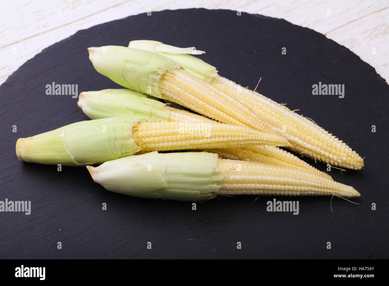 Fresh baby corn heap on the wood background Stock Photo - Alamy