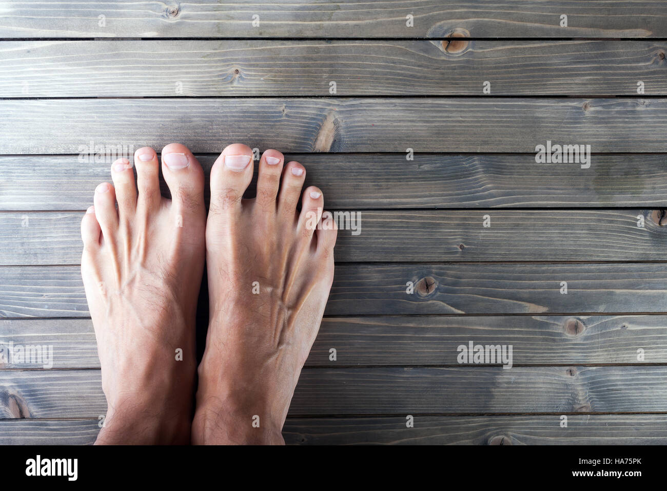 male feet on wooden background Stock Photo - Alamy