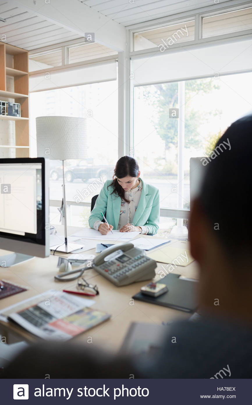 Female architect drafting blueprint at desk in office Stock Photo - Alamy