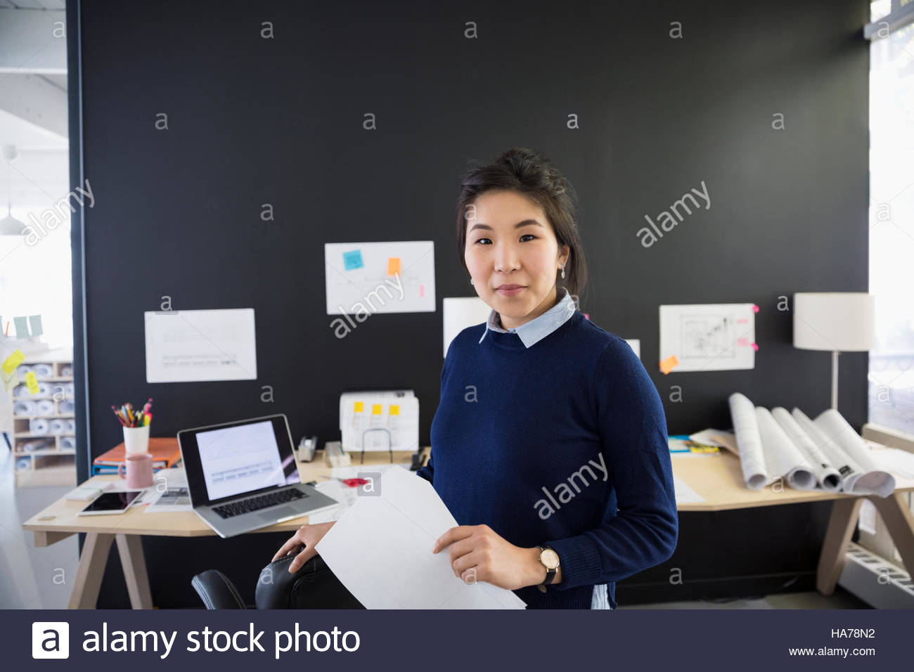 Portrait confident female architect with paperwork in office Stock ...