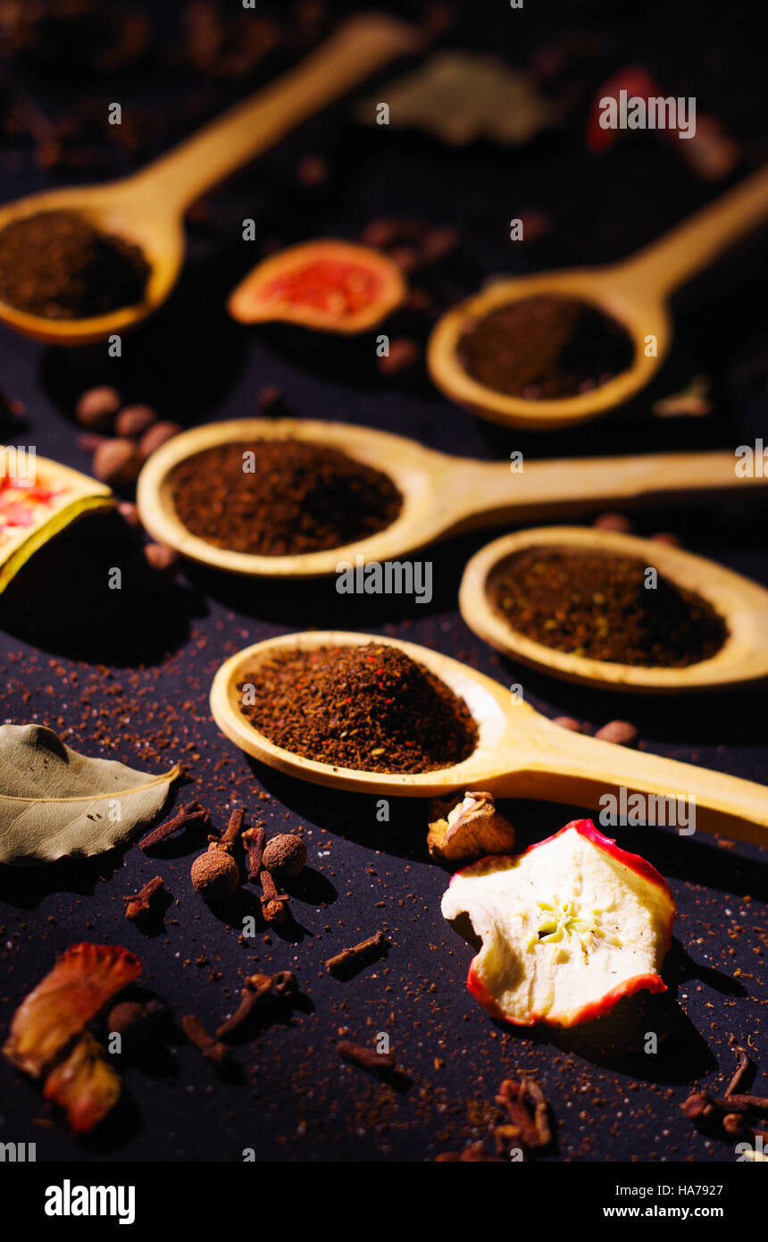 Closeup wooden rustic spoons filled up with fresh herbal tea powder ...