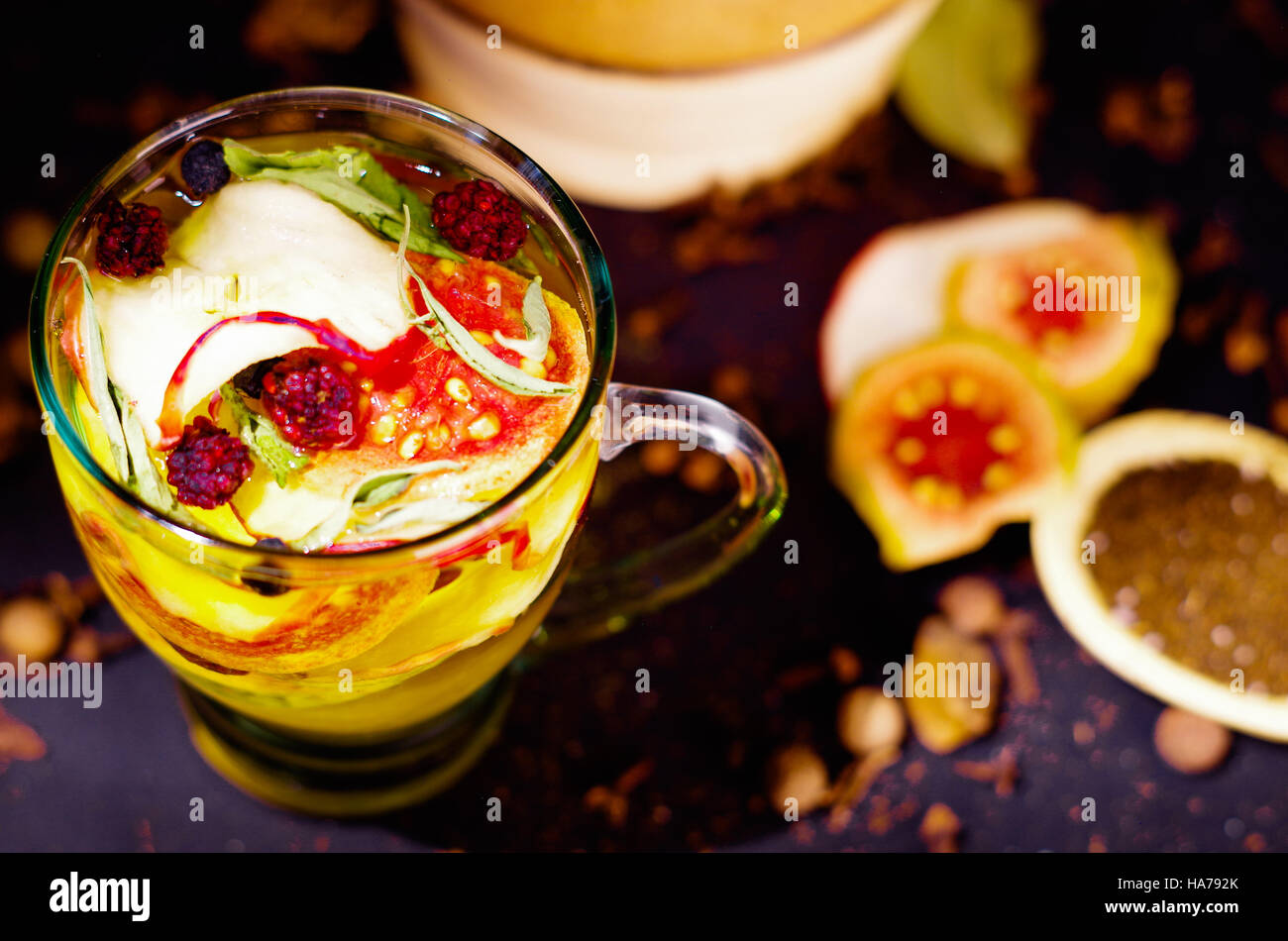 Transparent cup of infusion tea with colorful herbal selection inside ...