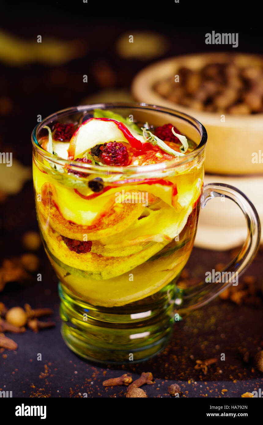 Transparent cup of infusion tea with colorful herbal selection inside ...