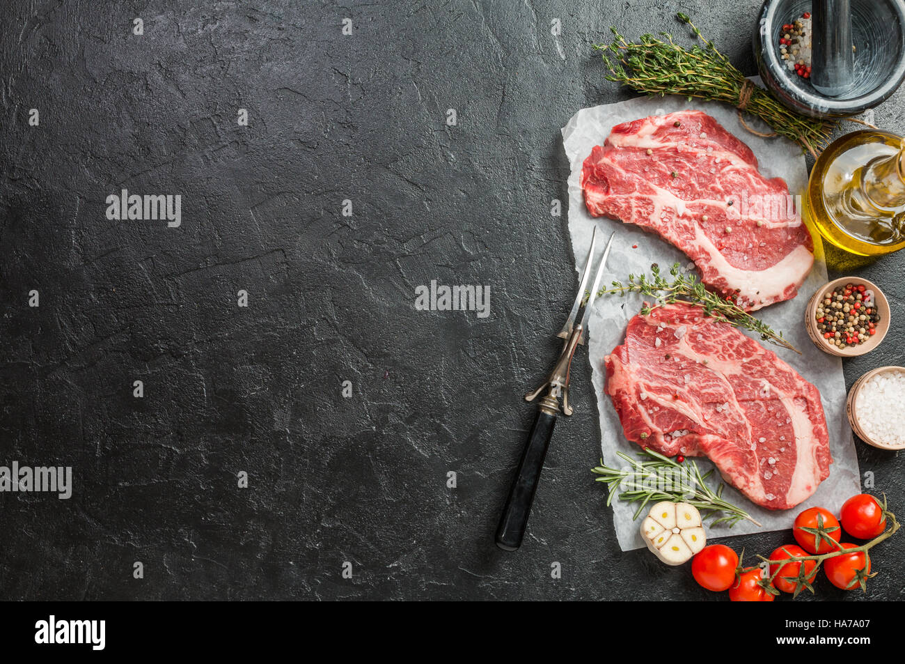 Two raw fresh marbled meat black angus steak ribeye and seasonings on ...