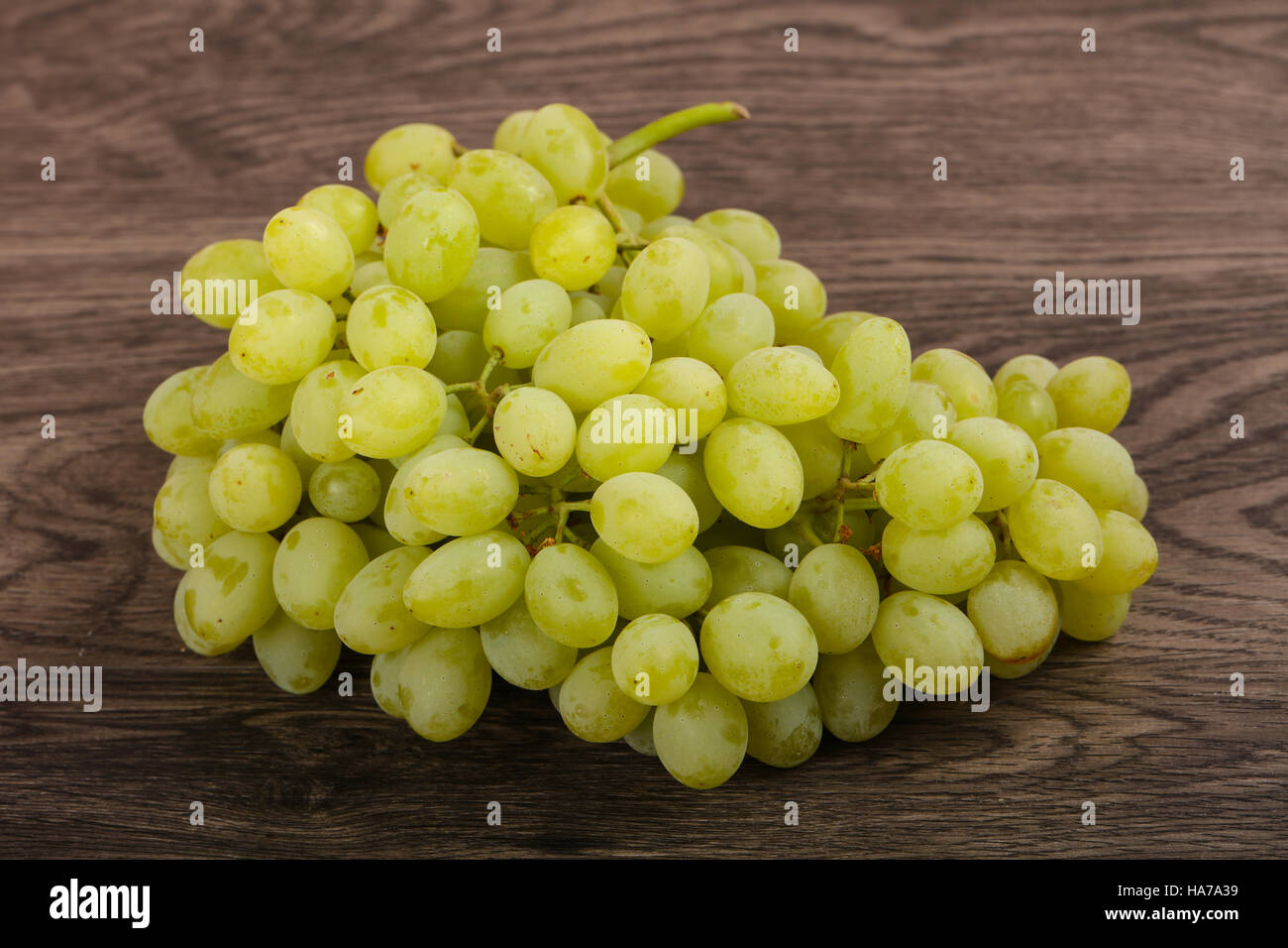Sweet yellow grape heap on the wood background Stock Photo - Alamy