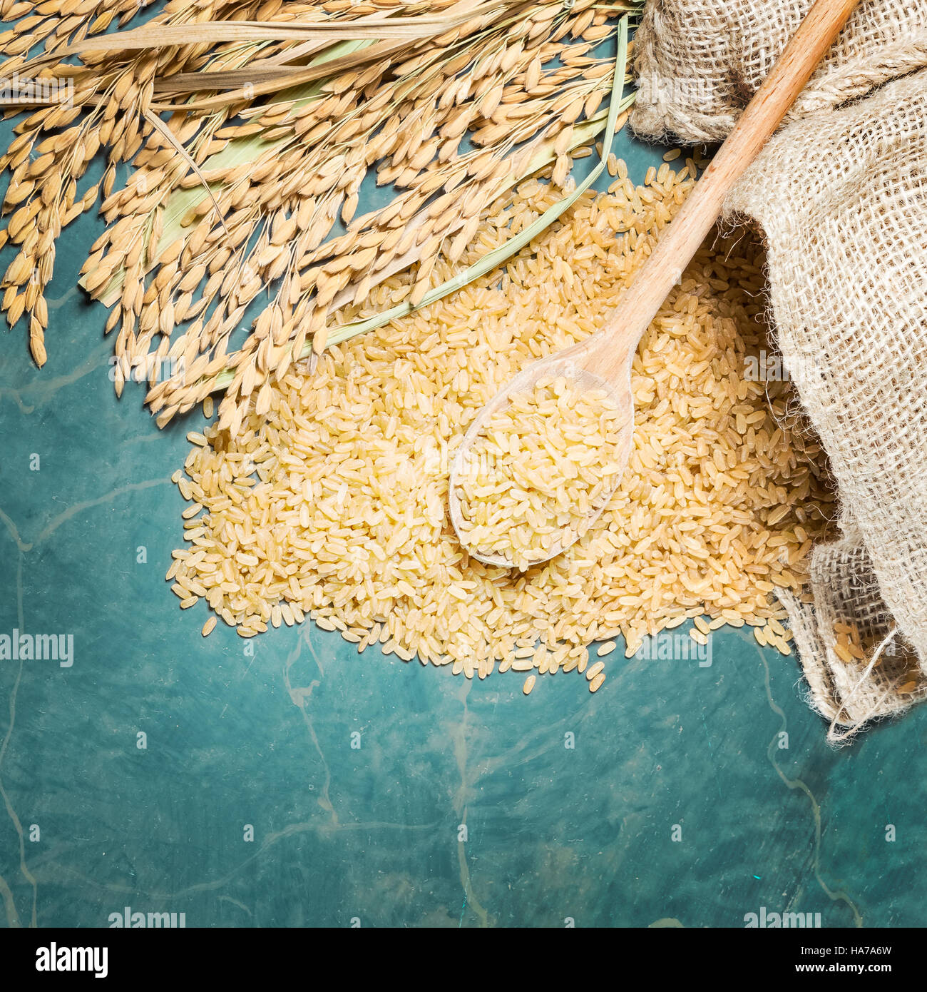 Brown rice uncooked in a bag with a pile of brown rice with over a full ...