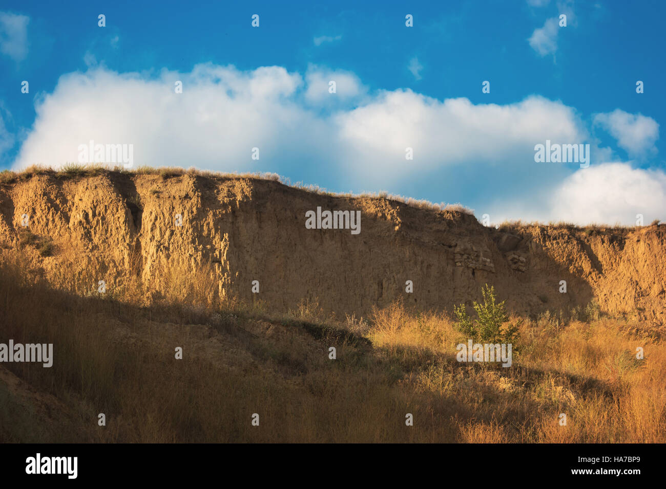 Sandy cliff and sky Stock Photo - Alamy