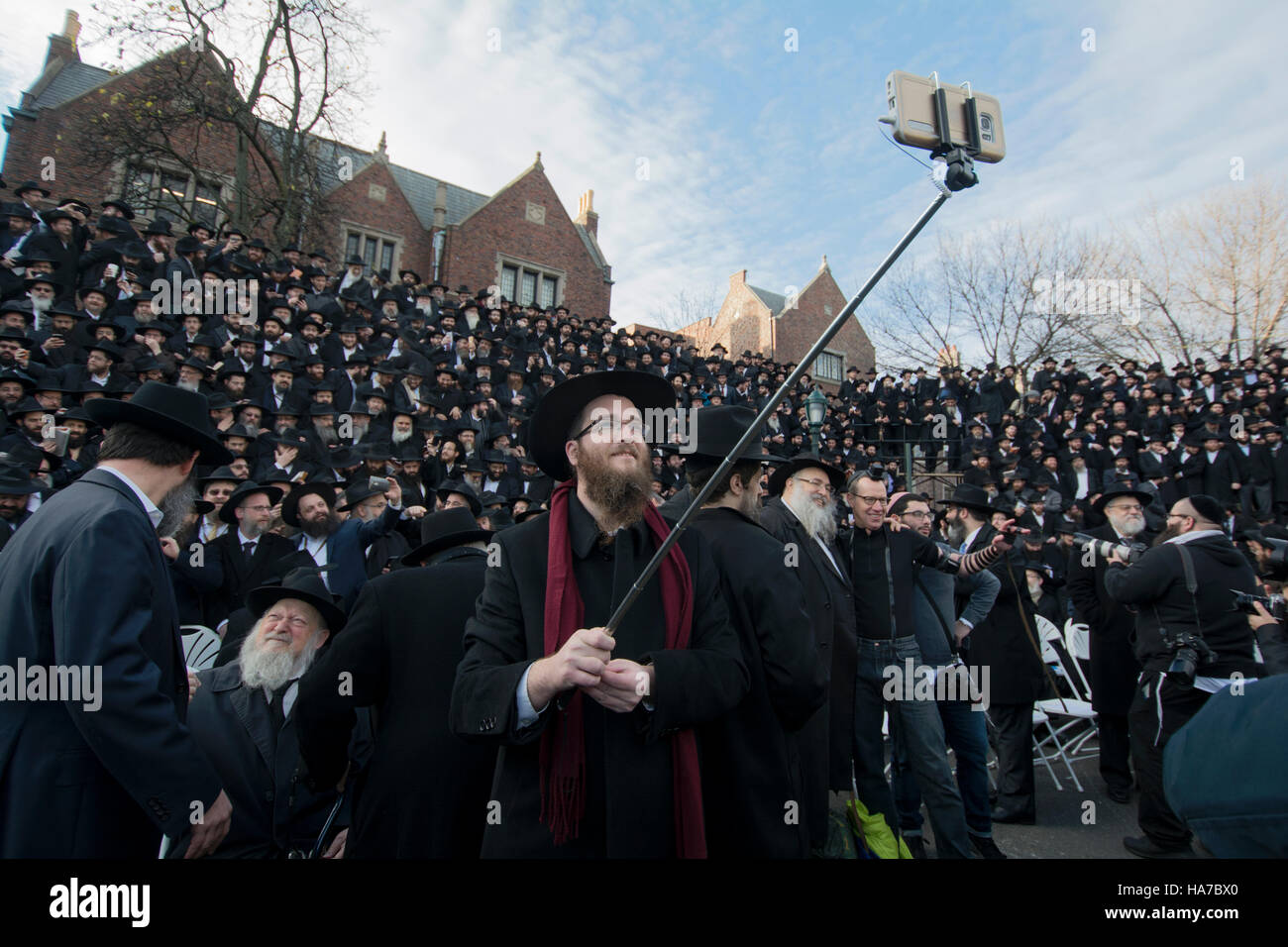 An orthodox Jewish rabbi takes a selfie in front of a large group of ...