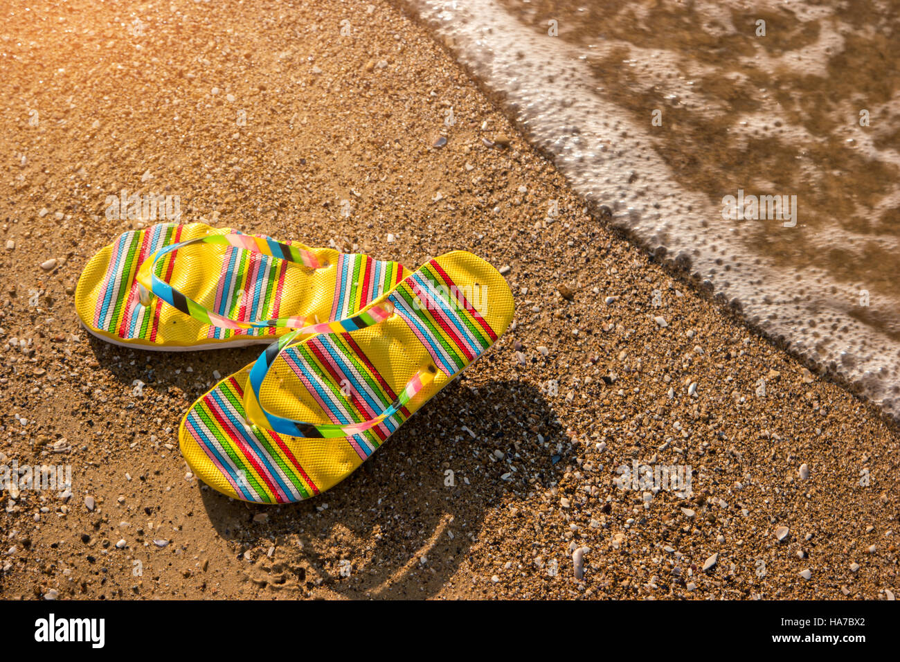 Flip flops on sand background Stock Photo - Alamy