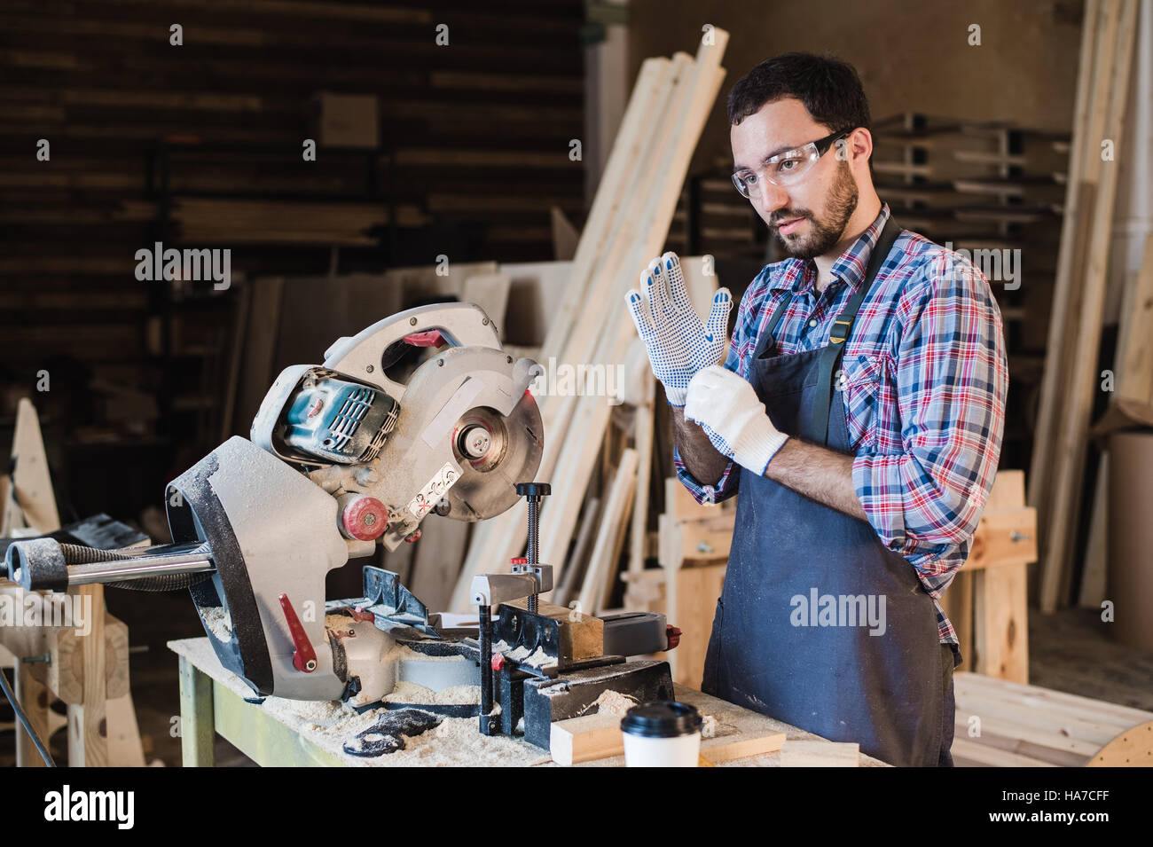 Young craftsman in uniform working at carpentry Stock Photo - Alamy