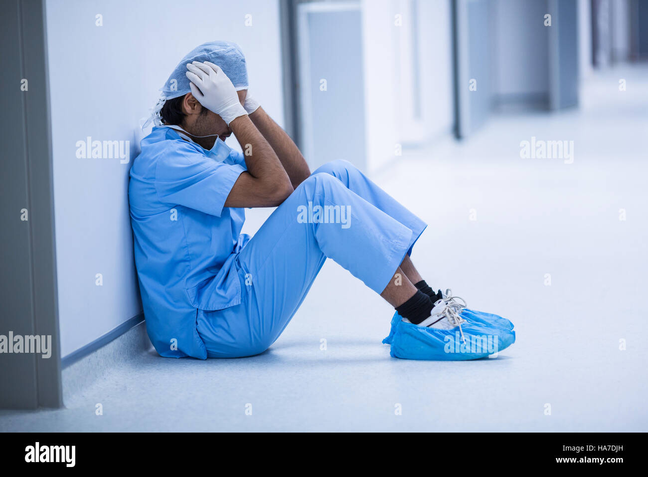 Sad surgeon sitting on a floor Stock Photo - Alamy
