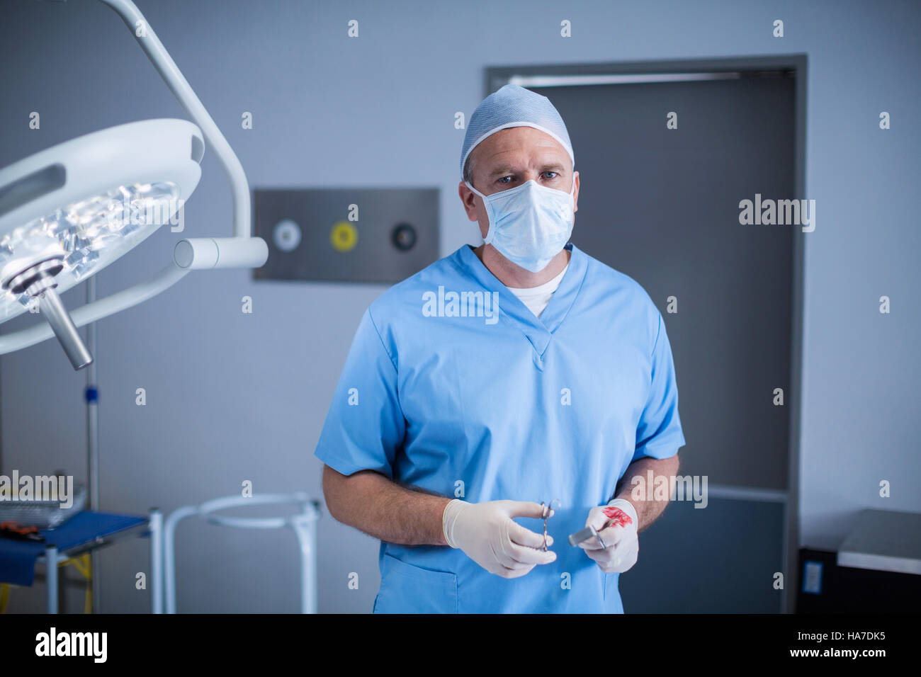 Portrait of surgeon holding surgical tool in operation room Stock Photo ...
