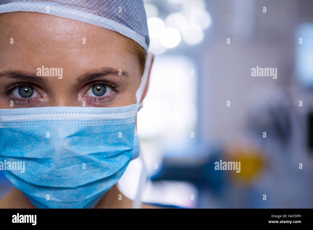 Portrait of female surgeon wearing surgical mask in operation theater ...
