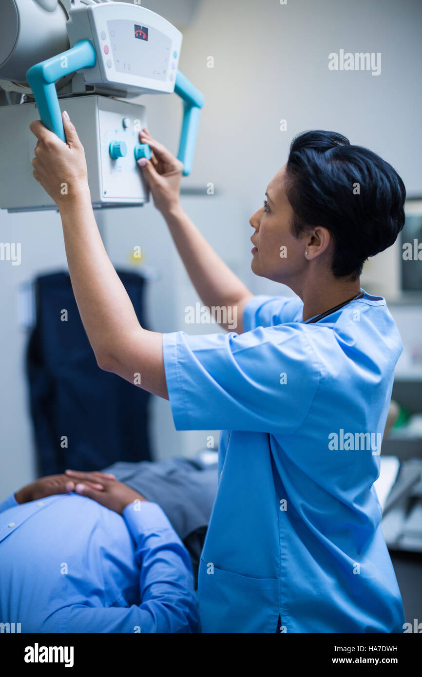 Female doctor sets up the machine to x-ray over patient Stock Photo - Alamy