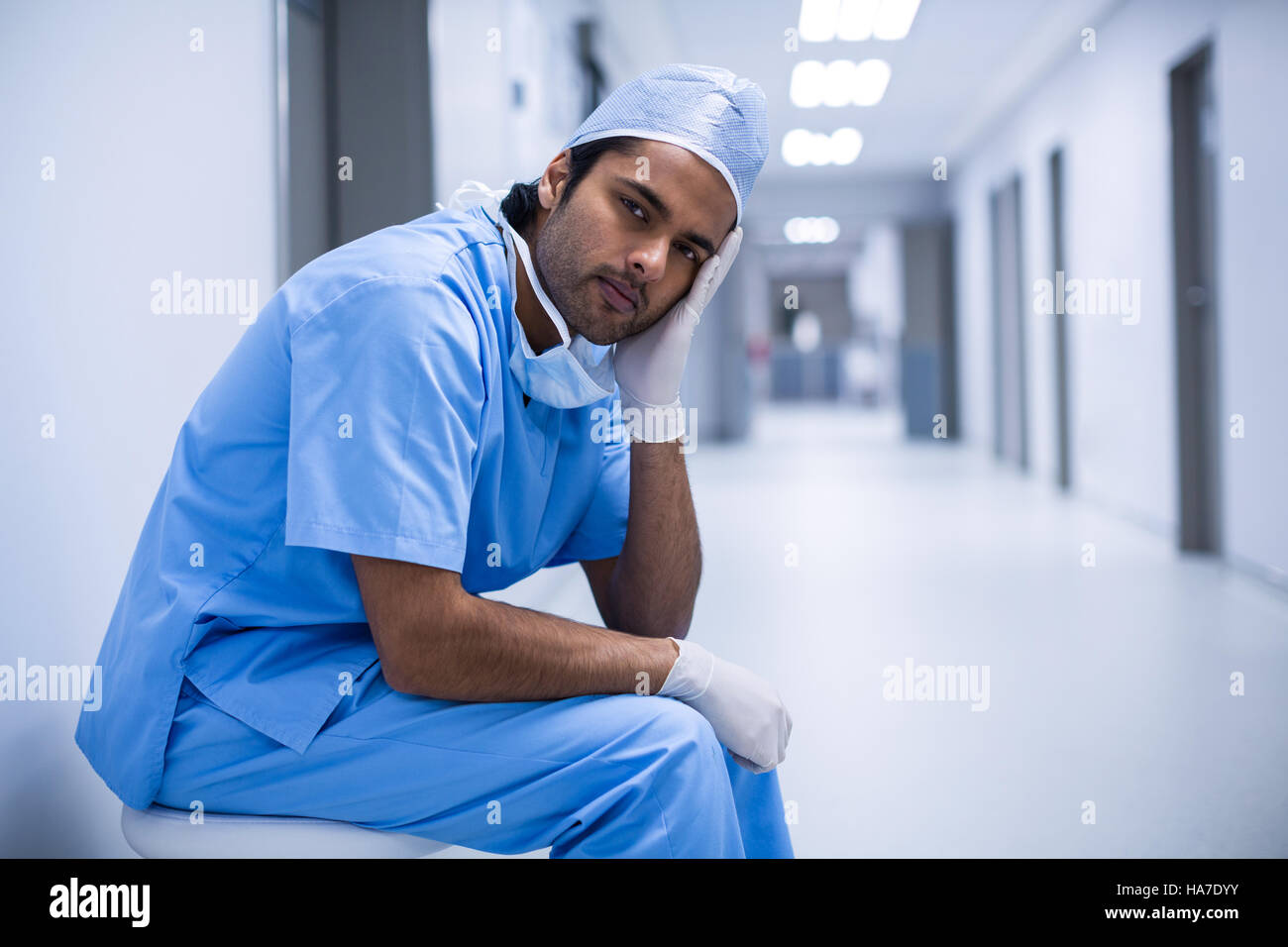 Sad surgeon sitting on a chair Stock Photo - Alamy