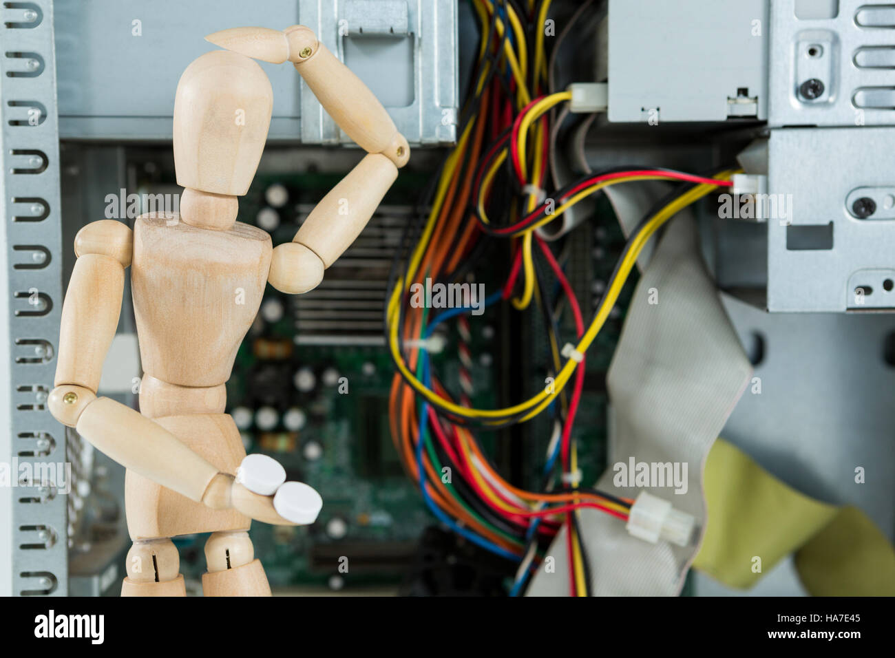 Wooden figurine fixing broken technology Stock Photo - Alamy