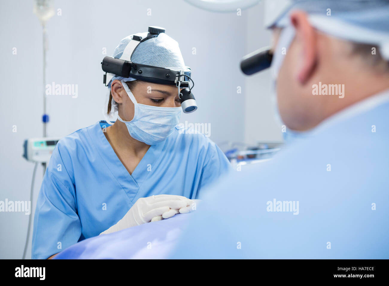 Surgeons wearing surgical loupes while operating patient Stock Photo ...