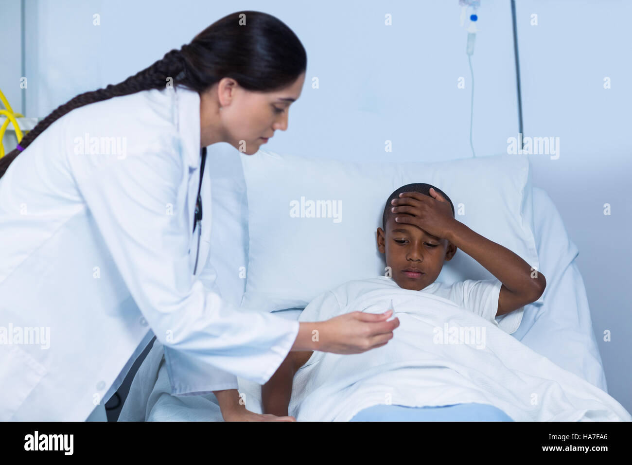 Female doctor checking fever from digital thermometer Stock Photo - Alamy