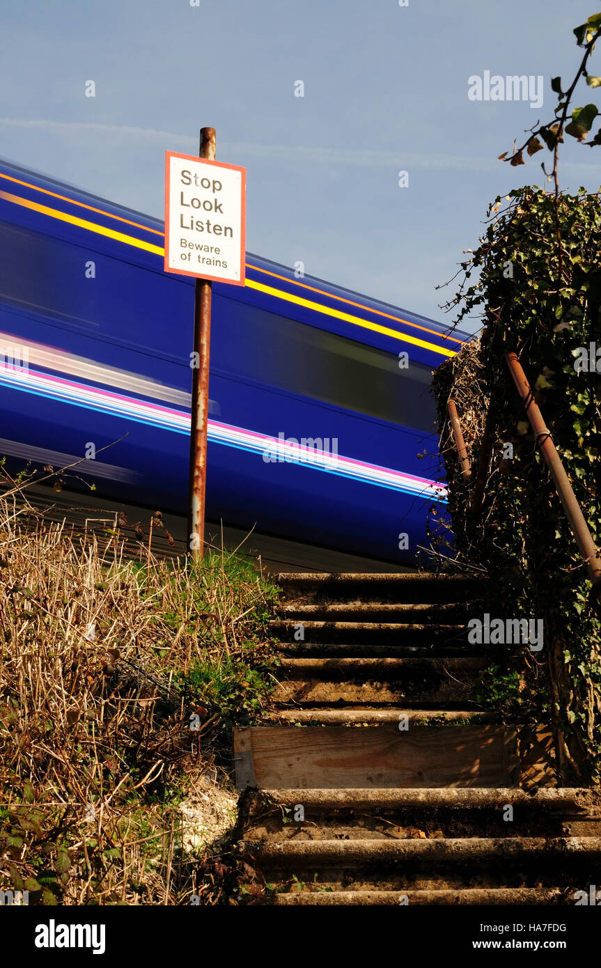 A high speed train passing over a footpath crossing Stock Photo - Alamy