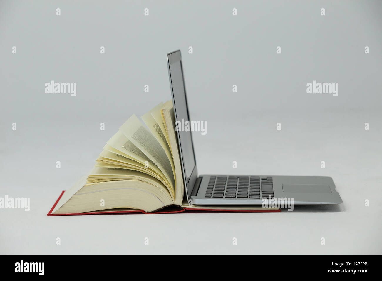 Laptop on open book Stock Photo - Alamy
