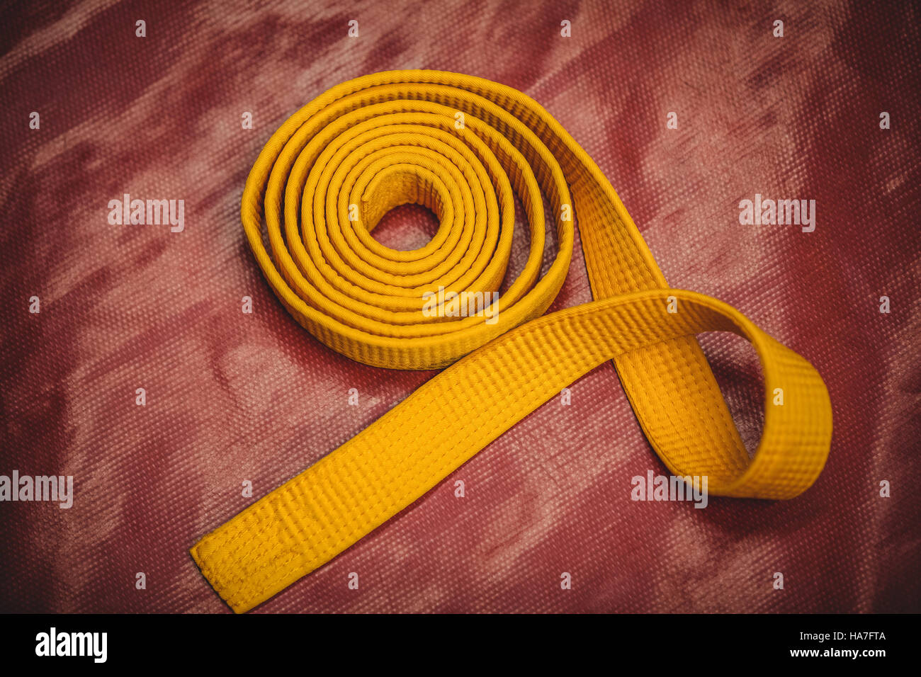 Karate yellow belt on red background Stock Photo - Alamy