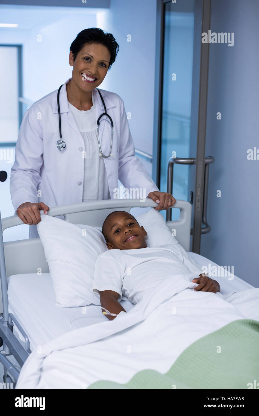 Portrait of doctor standing while patient lying on emergency stretcher ...