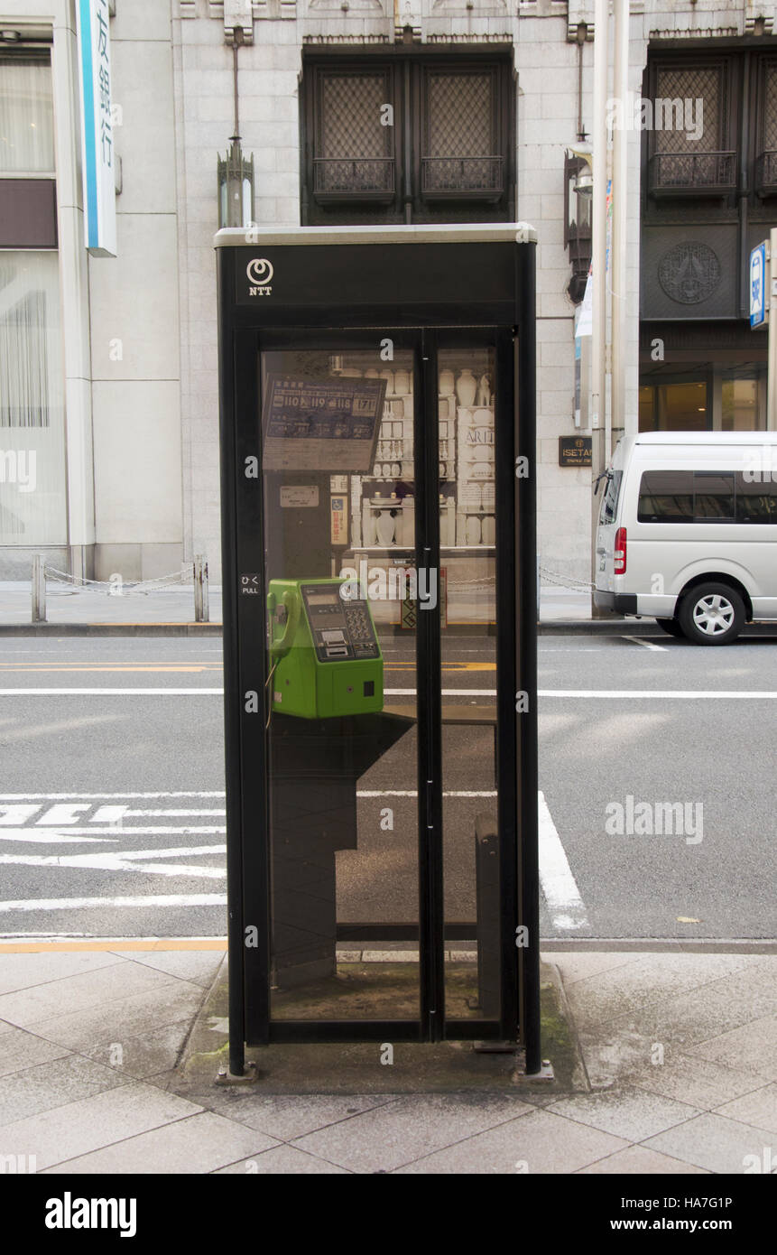 Public telephone on pathway beside traffic road for people use phone at ...