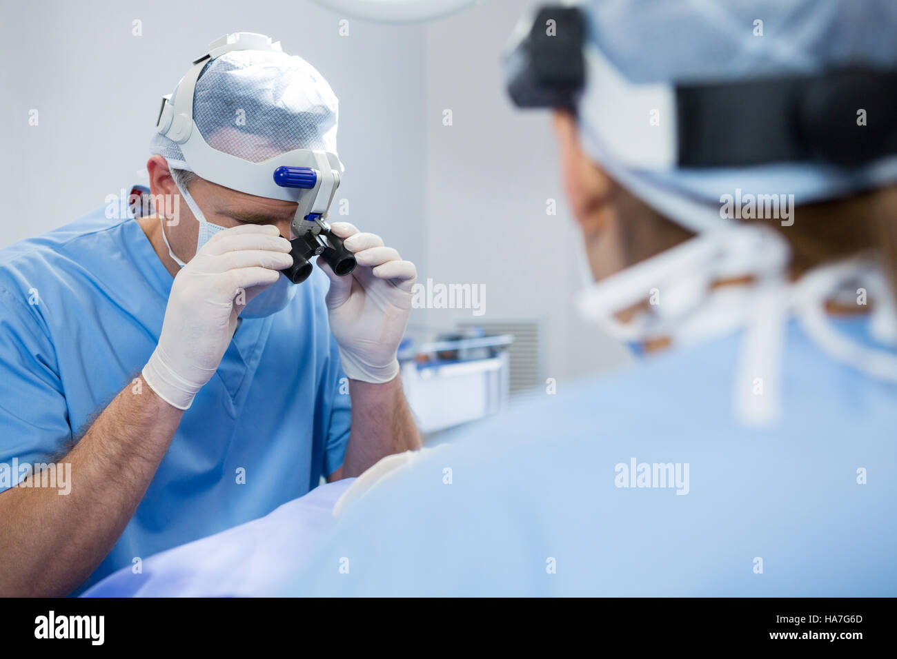 Surgeons wearing surgical loupes while operating patient Stock Photo ...