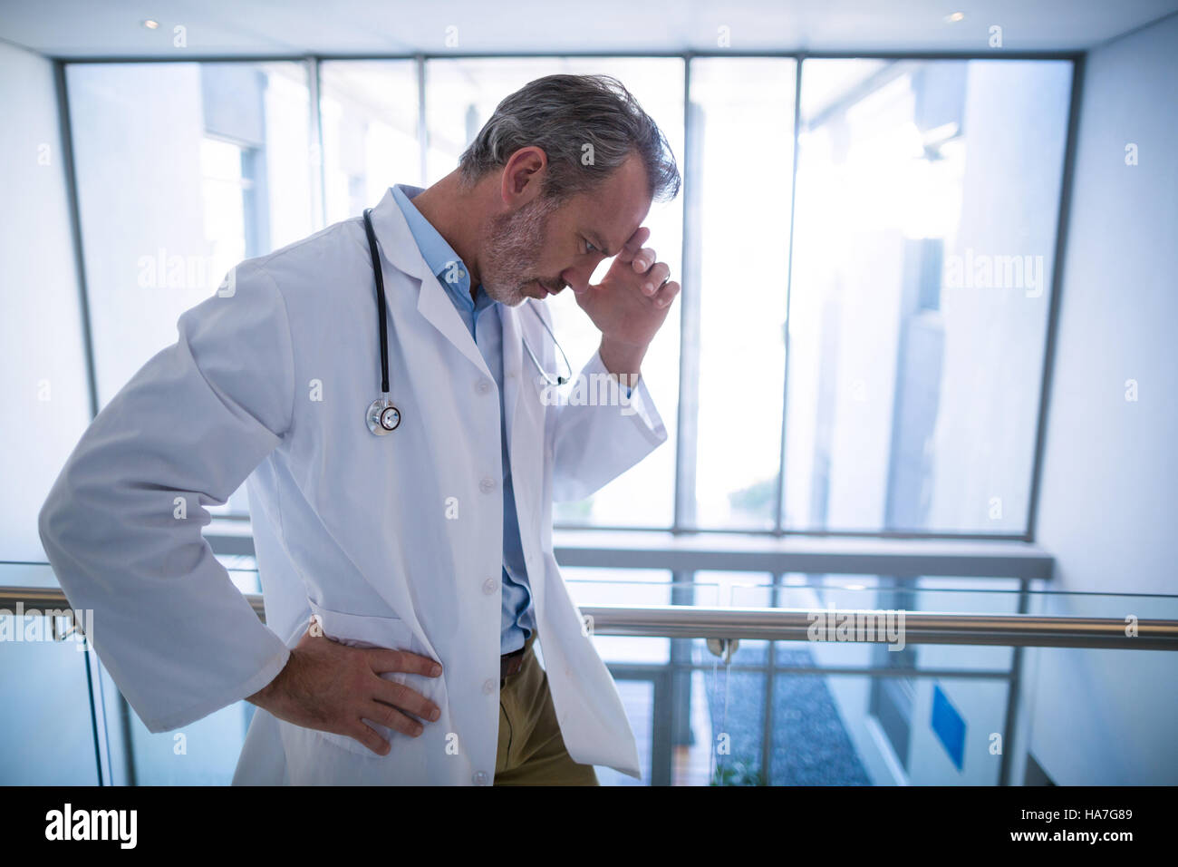 Sad doctor standing in corridor Stock Photo - Alamy