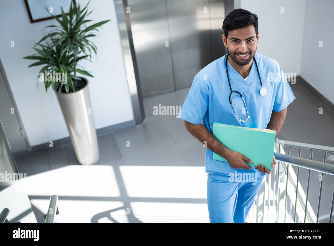 Smiling doctor standing with file in hospital Stock Photo - Alamy