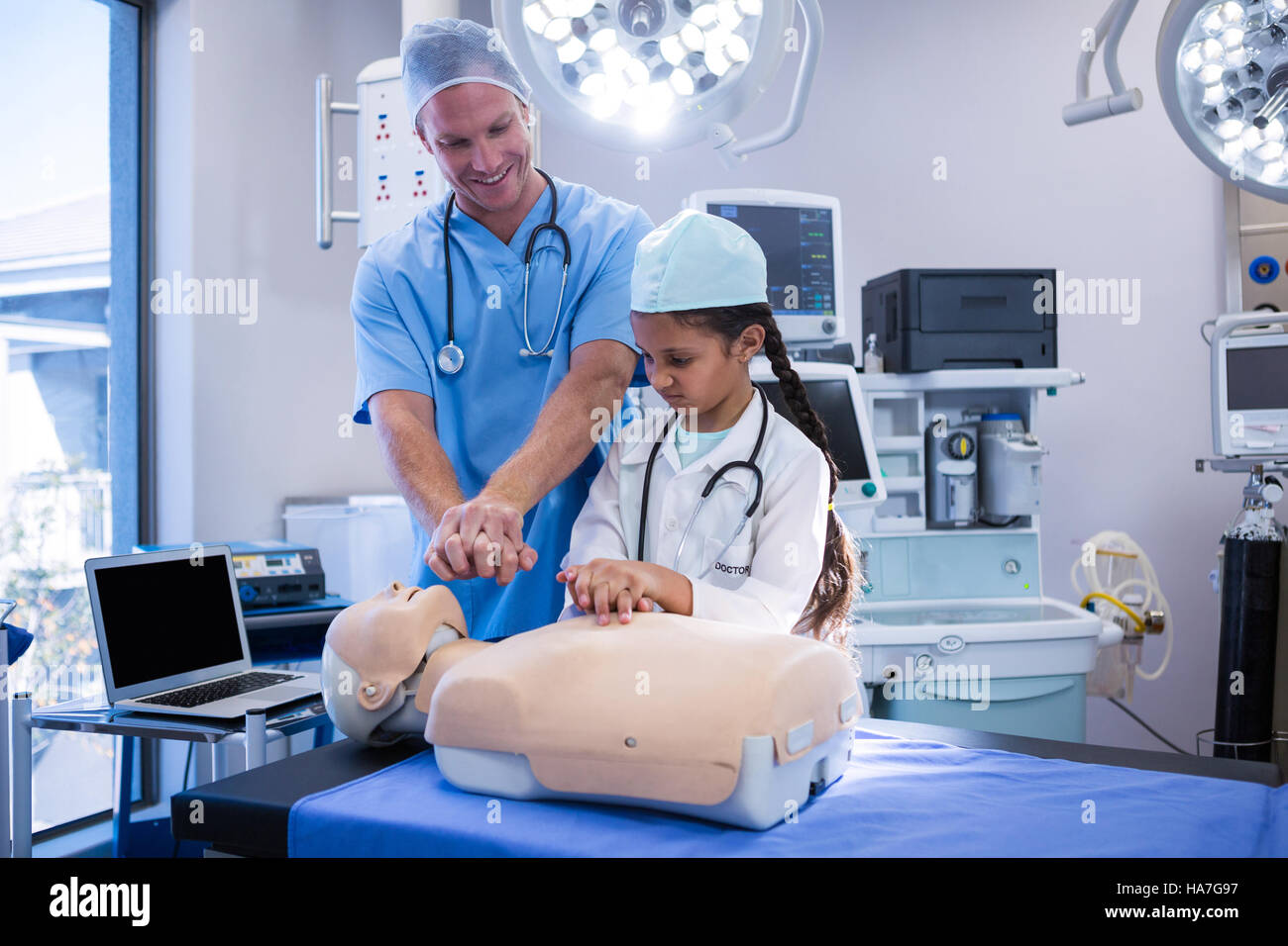 Doctor assisting girl in examining on dummy Stock Photo - Alamy
