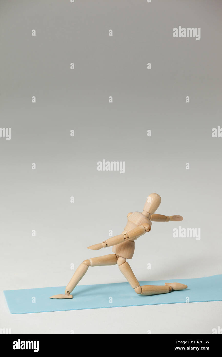 Wooden figurine exercising on exercise mat Stock Photo - Alamy