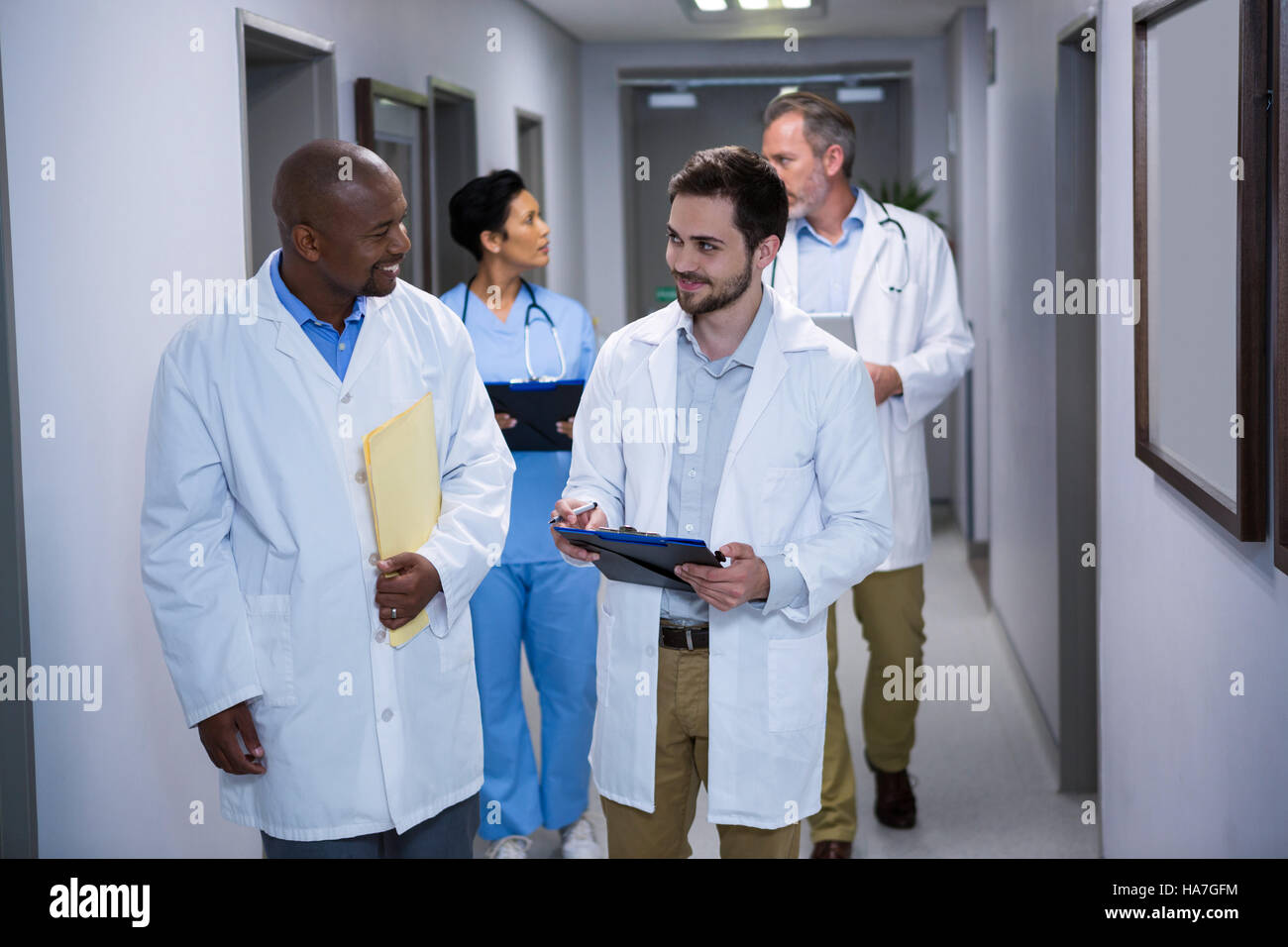 Doctors interacting with each other in corridor Stock Photo - Alamy