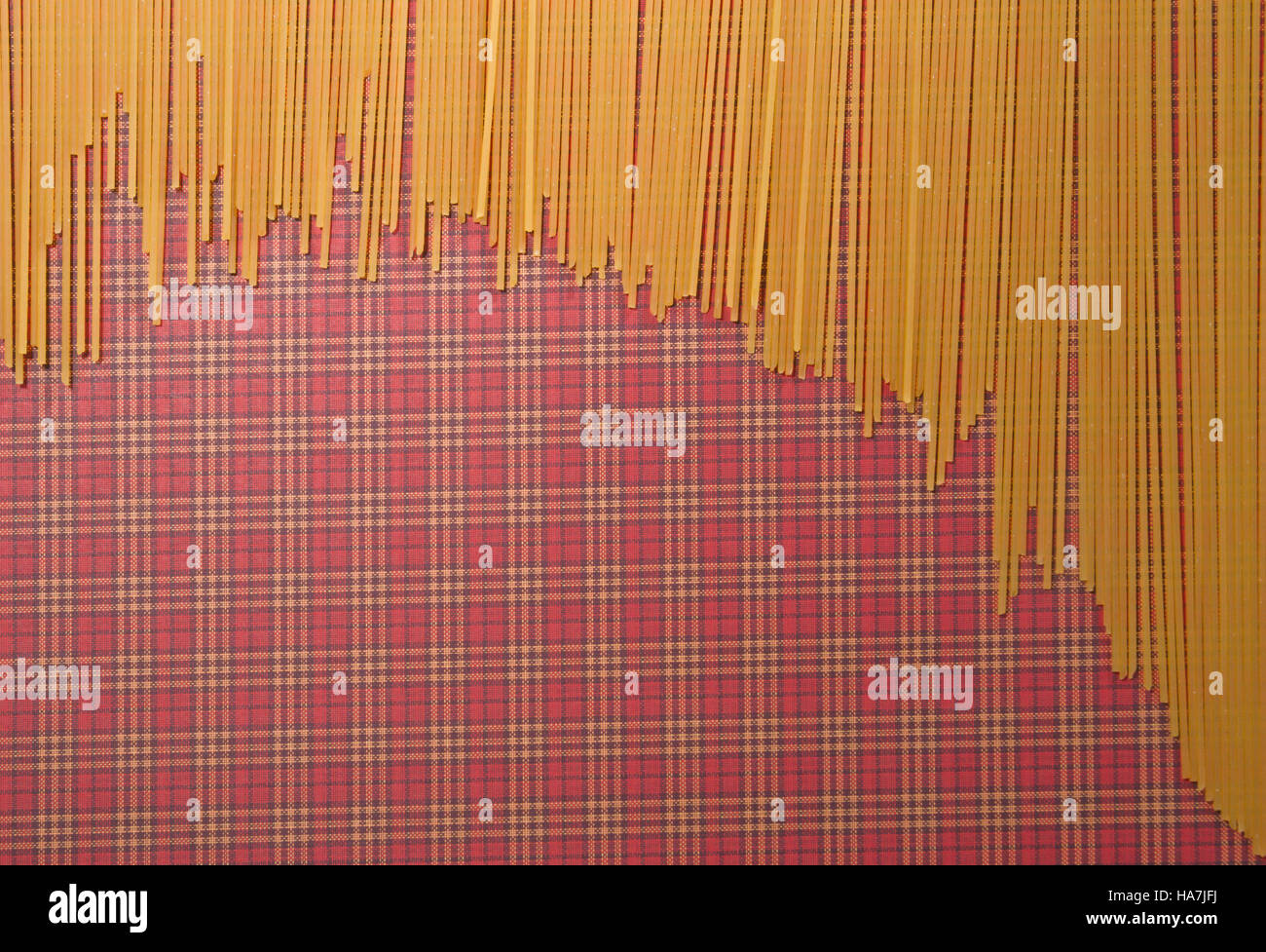 Yellow italian spaghetti pasta on red background Stock Photo - Alamy