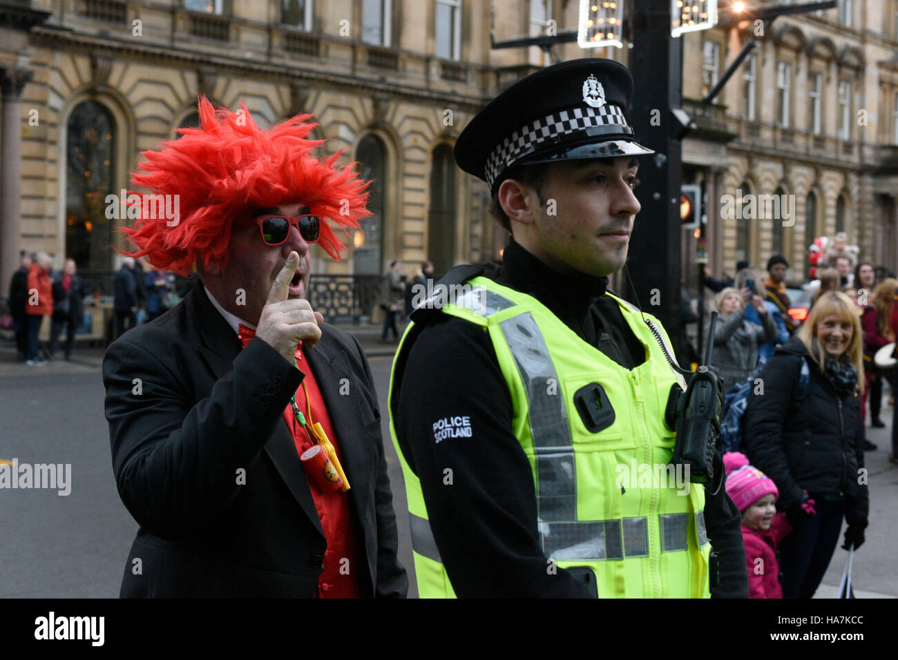 A performers stands behind a police officer during the medieval themed ...