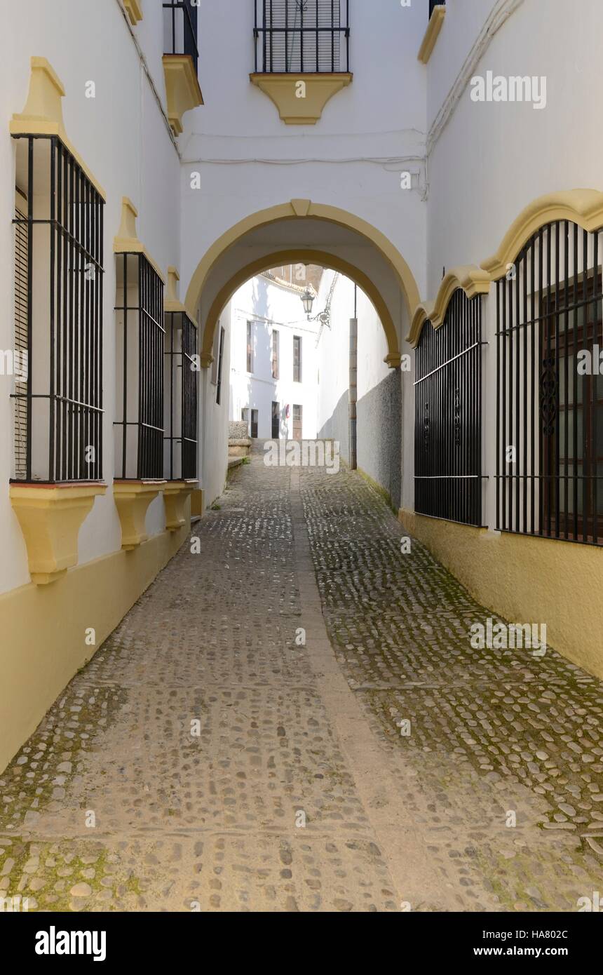 Paving stone way in white alley with a touch of yellow in Ronda ...