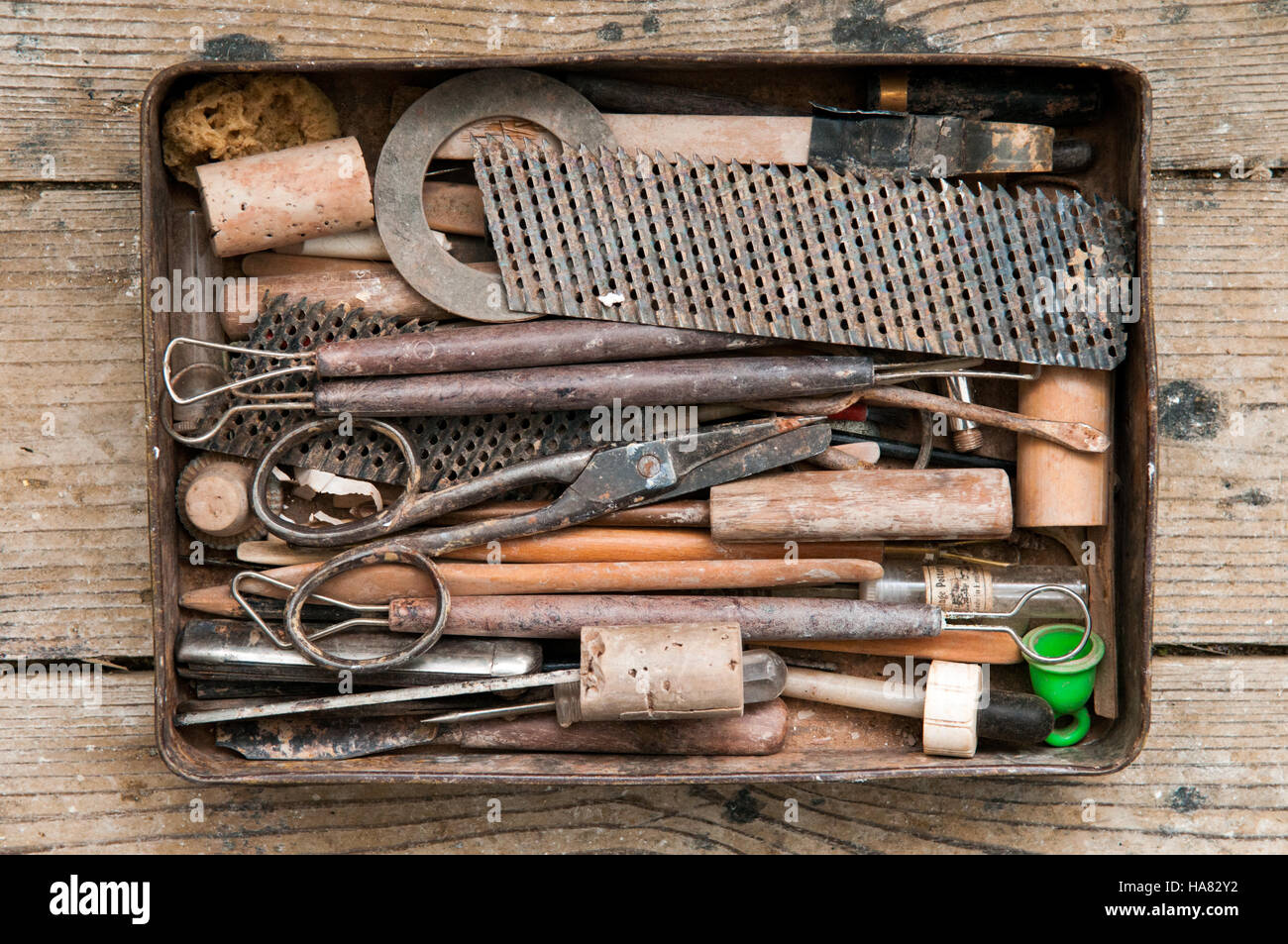 Vintage style tools in a retro tin tool box on a the workshop table ...