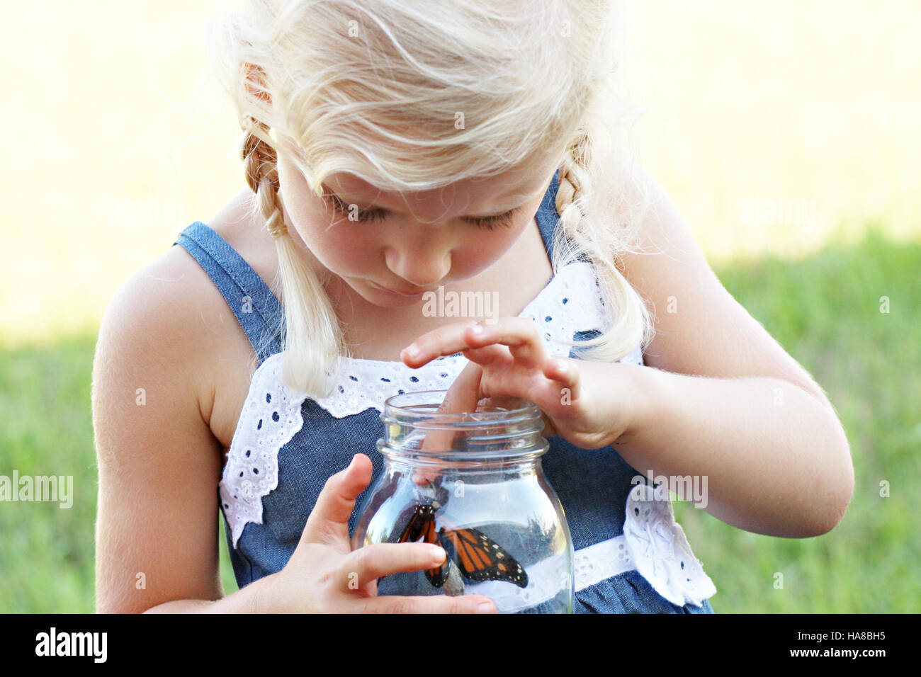A young monarch butterfly enthusiast at a national park observes and ...